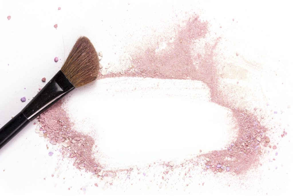 Makeup brush on white background, with traces of powder - Azra Magazin